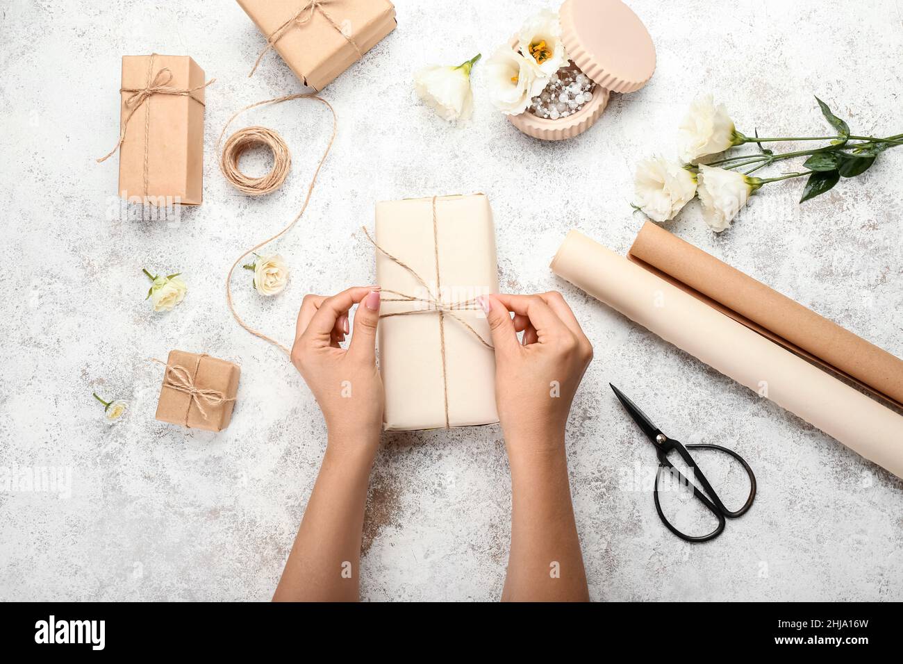 Woman packing gift box on grunge background Stock Photo - Alamy
