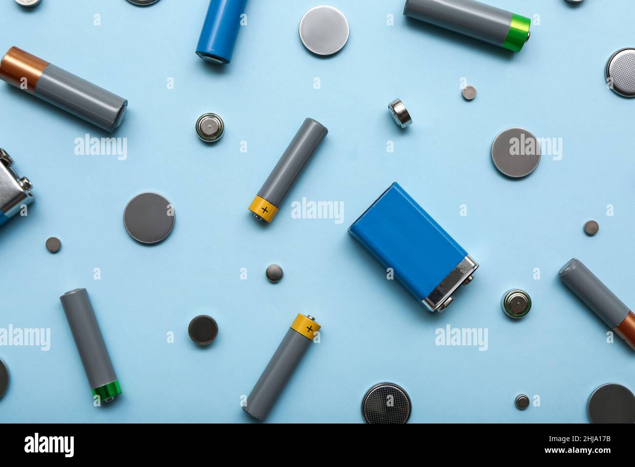 Different batteries on blue background Stock Photo - Alamy