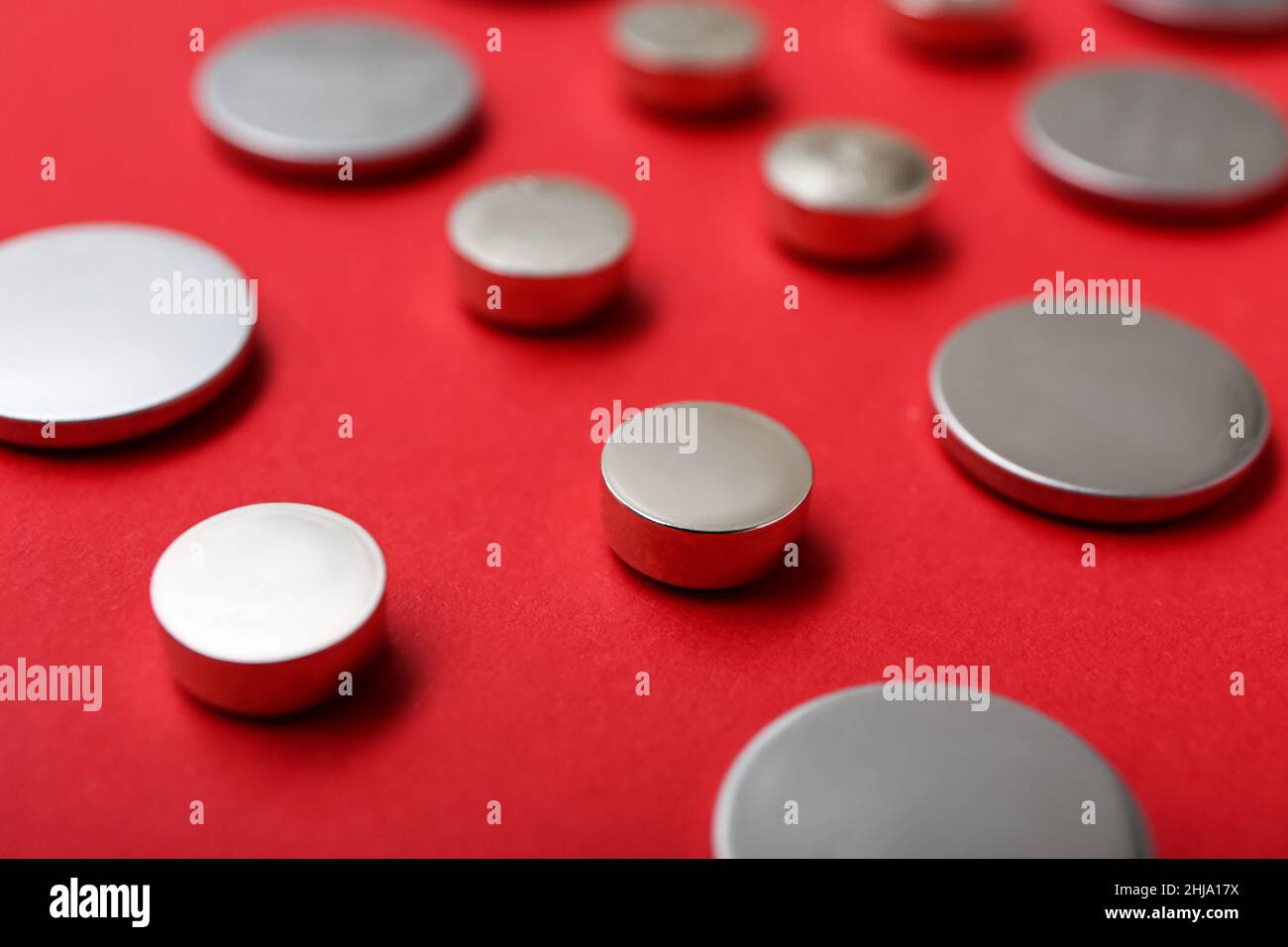 Metal lithium button cell batteries on red background, closeup Stock ...