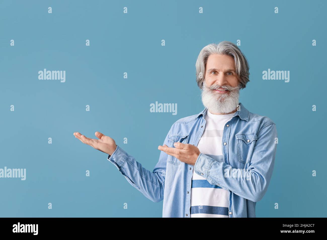 Senior handsome man showing something hi-res stock photography and ...