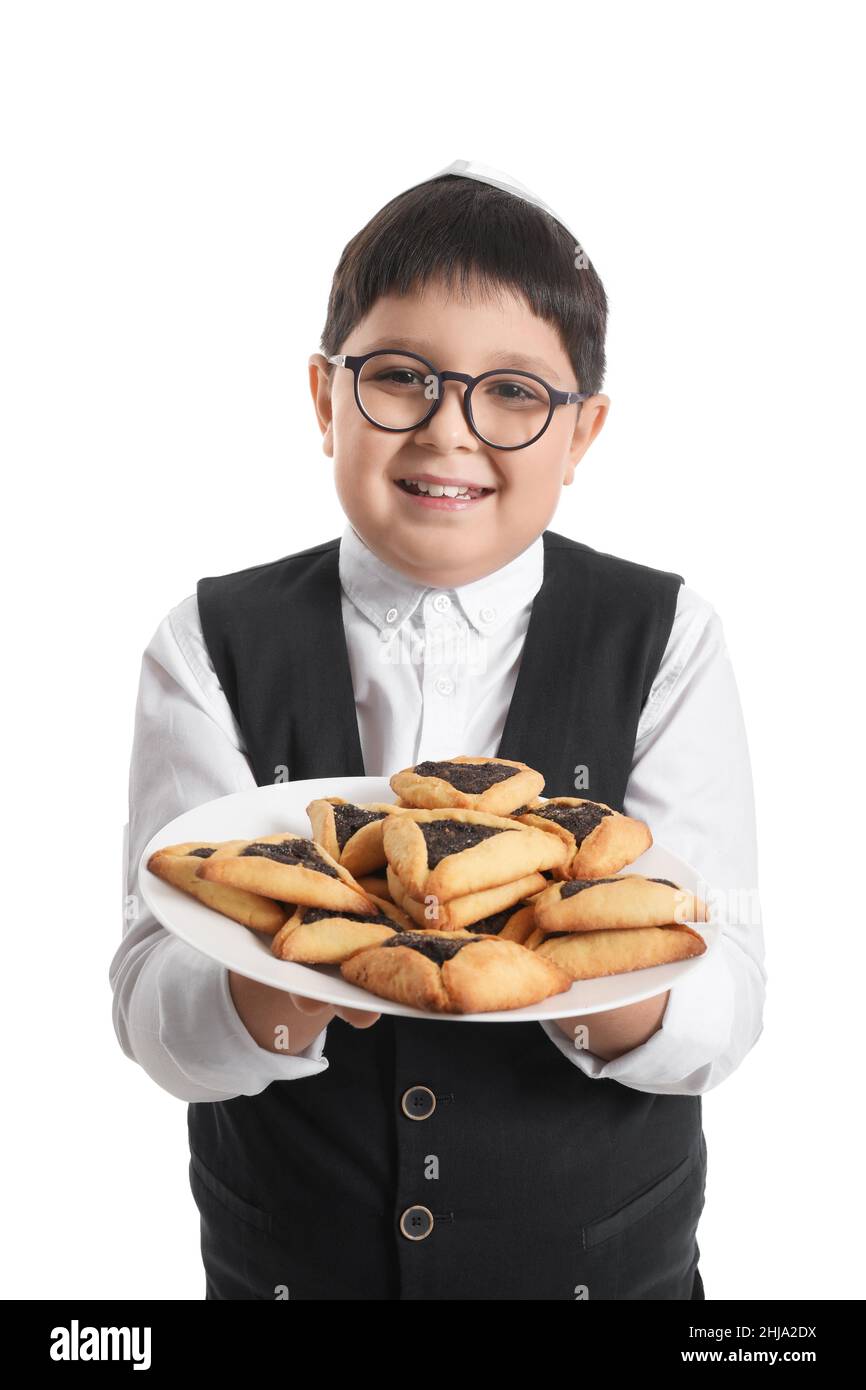 Little Jewish boy with tasty Hamantaschen for Purim holiday on white ...