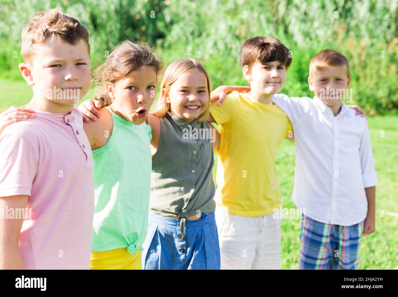Portrait of five glad children who are walking and posing in park Stock ...
