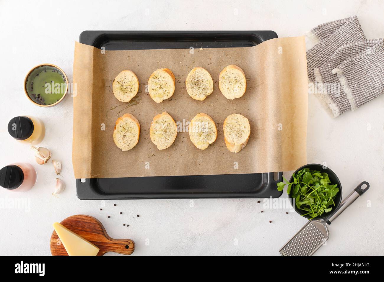 Baking sheet with pieces of bread for preparing croutons and spices on ...