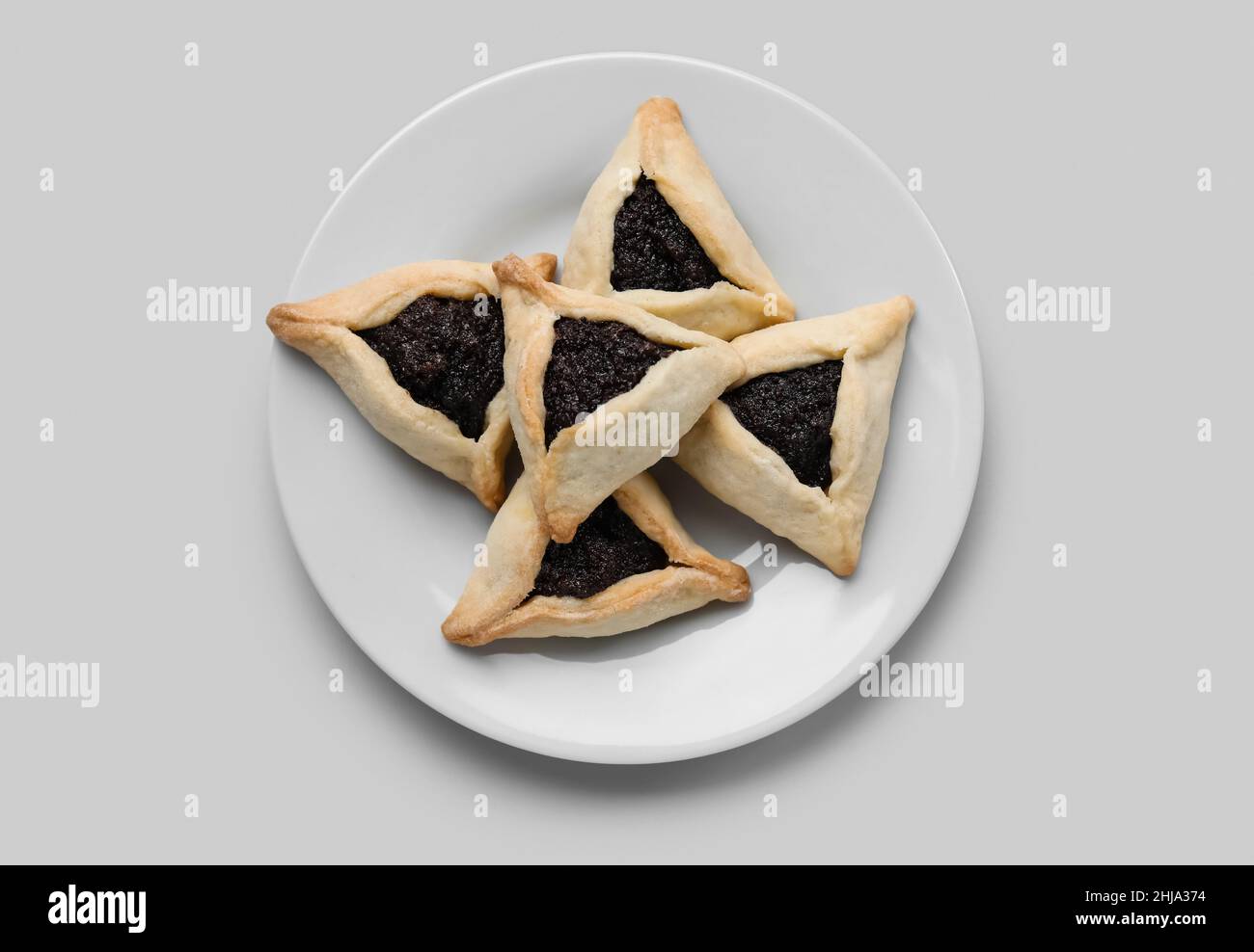 Plate with tasty hamantaschen for Purim holiday on grey background ...