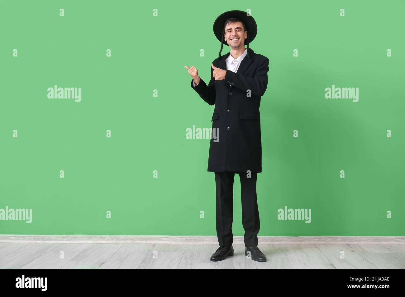 Hasidic Jewish man pointing at something on color background Stock ...