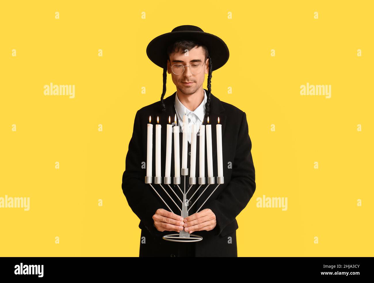 Jewish man with menorah on color background Stock Photo - Alamy