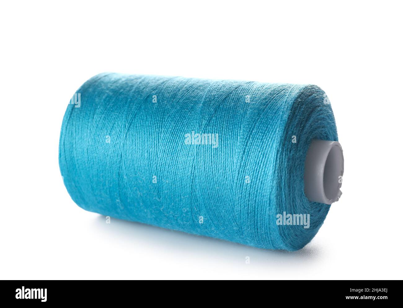 Blue sewing thread spool on white background Stock Photo - Alamy
