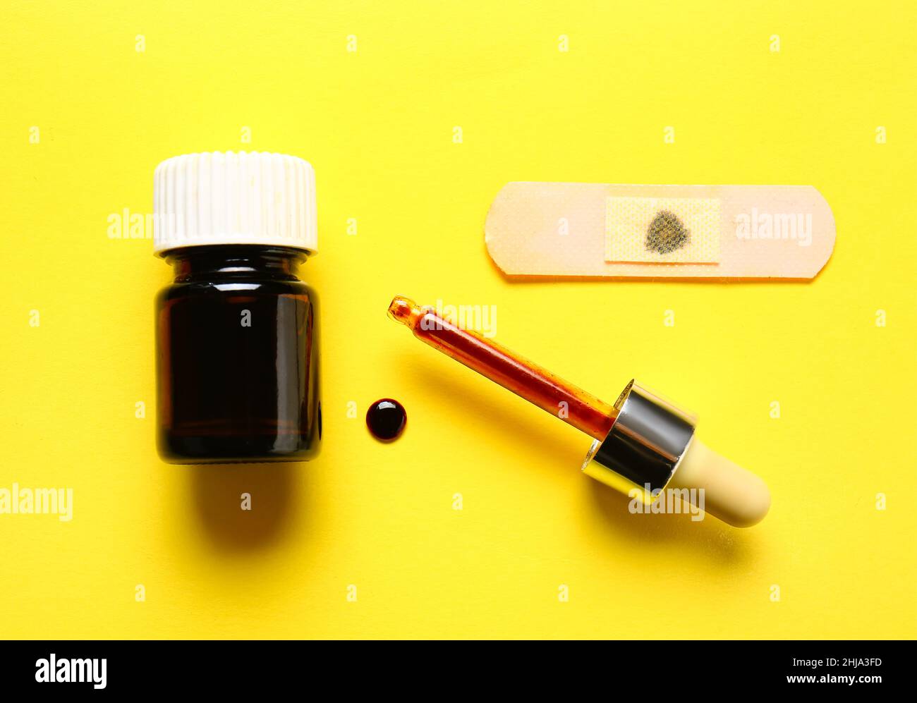 Bottle with iodine, pipette and medical plaster on yellow background ...