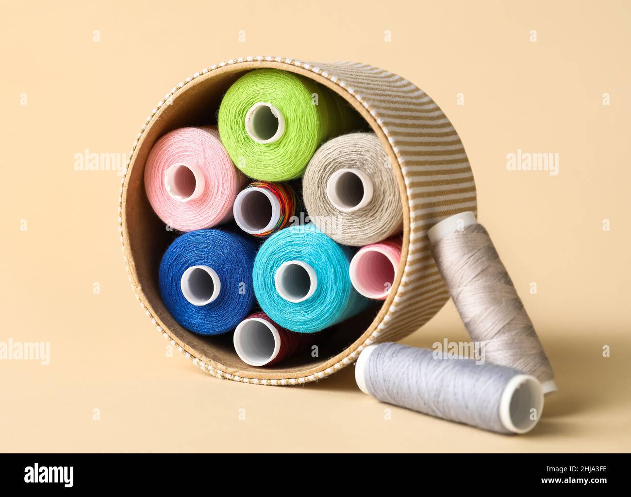 Box with different sewing thread spools on light background Stock Photo ...