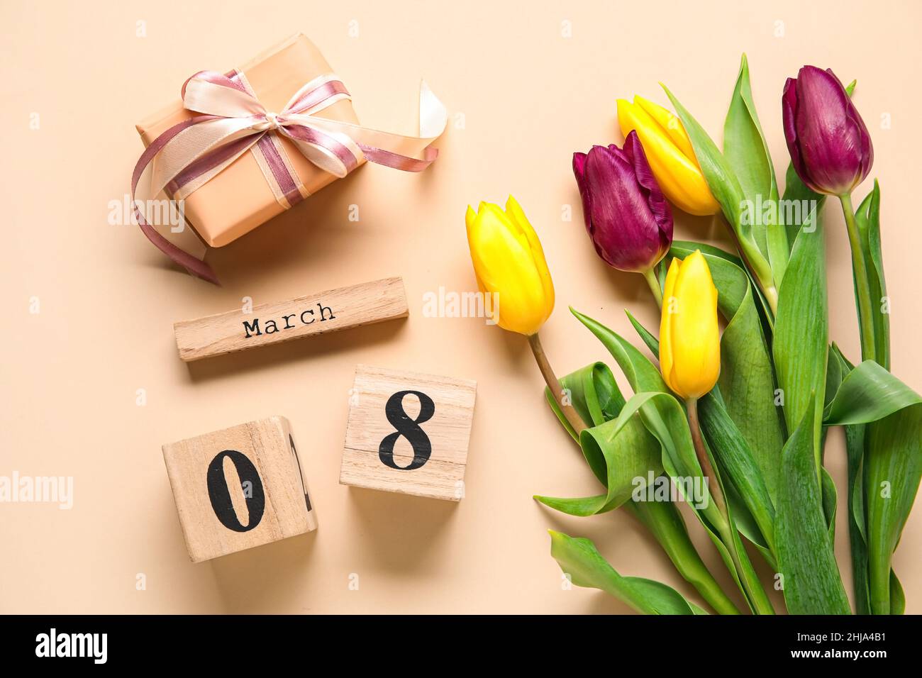 Wooden cube calendar with date MARCH 8, gift box and bouquet of tulips ...