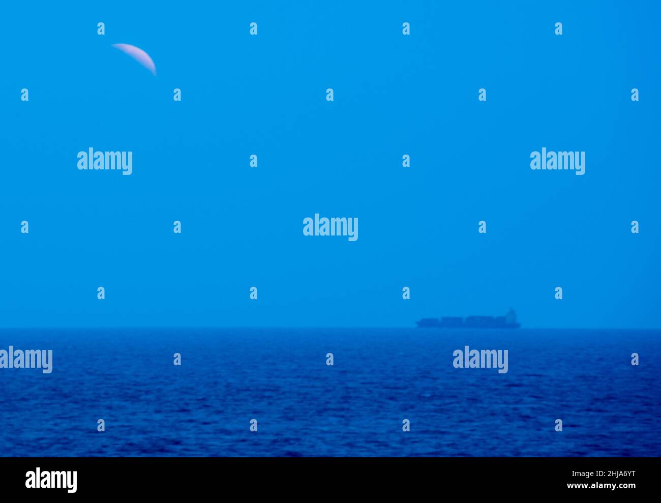 Ship on ocean seen early evening through the mist during a lunar ...