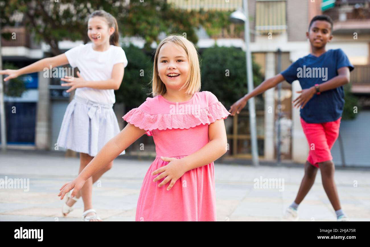 Smiling tween girl street dancer posing during performance with group ...