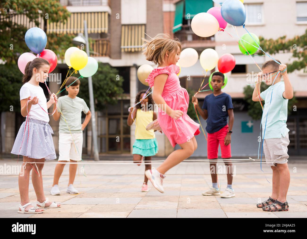 Kids playing with Chinese jumping rope outdoors Stock Photo - Alamy