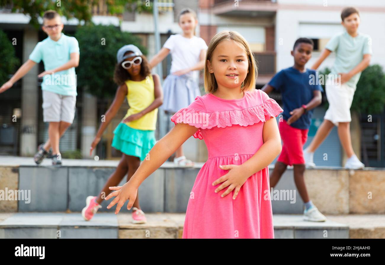 Smiling tween girl street dancer posing during performance with group ...