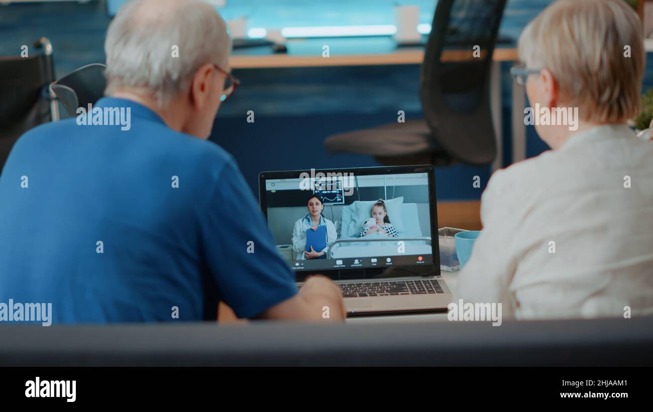 Grandparents talking to doctor and child in hospital on video call ...