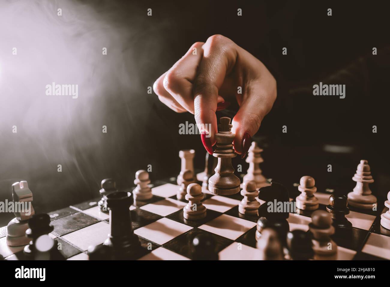 Woman player playing board intelligence game - wooden chess. Female arm ...
