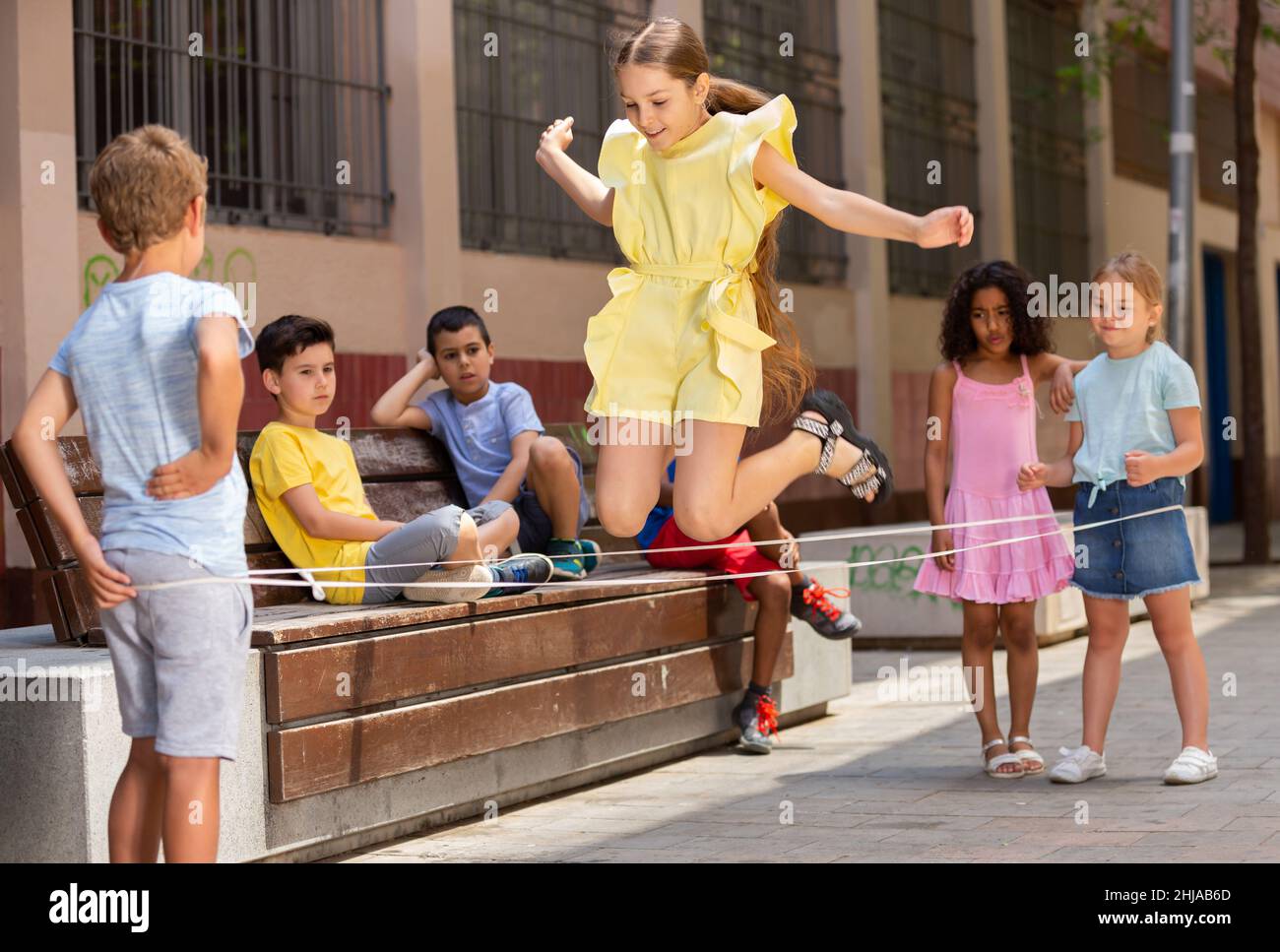 Happy little girl jumping game by rubber band with friends Stock Photo ...