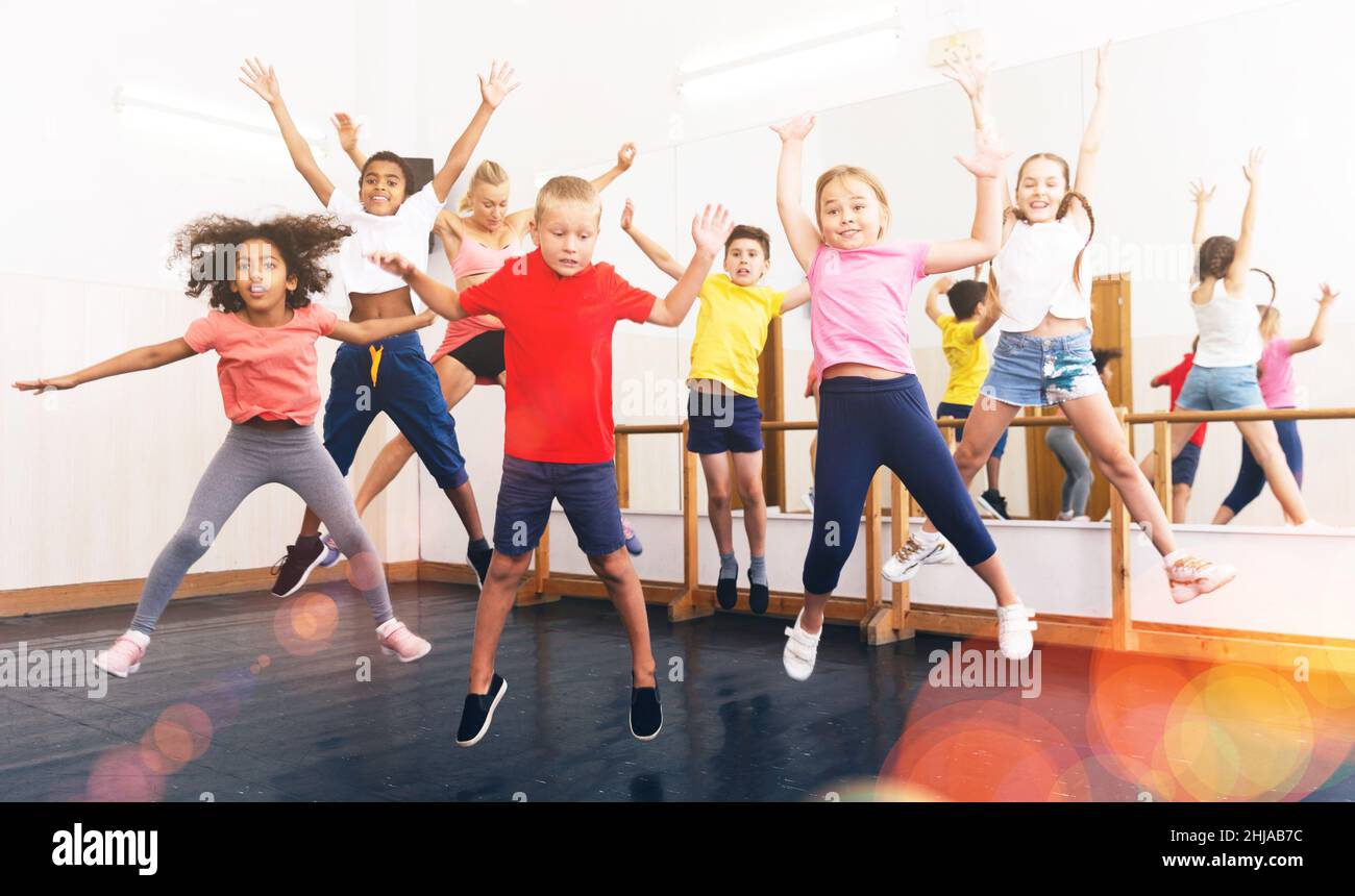 Cheerful preteen boys and girls jumping in dance class Stock Photo - Alamy