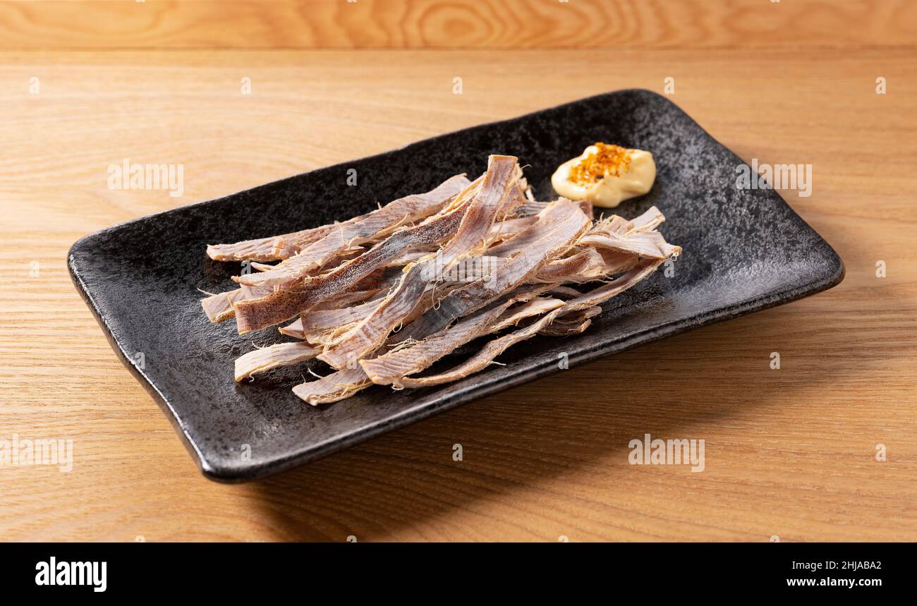 Dried squid and mayonnaise placed on a wooden background. Surume is a ...