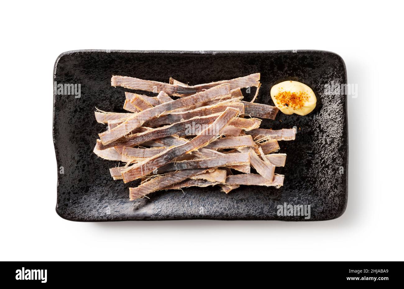 Dried squid and mayonnaise on a plate placed on a white background ...