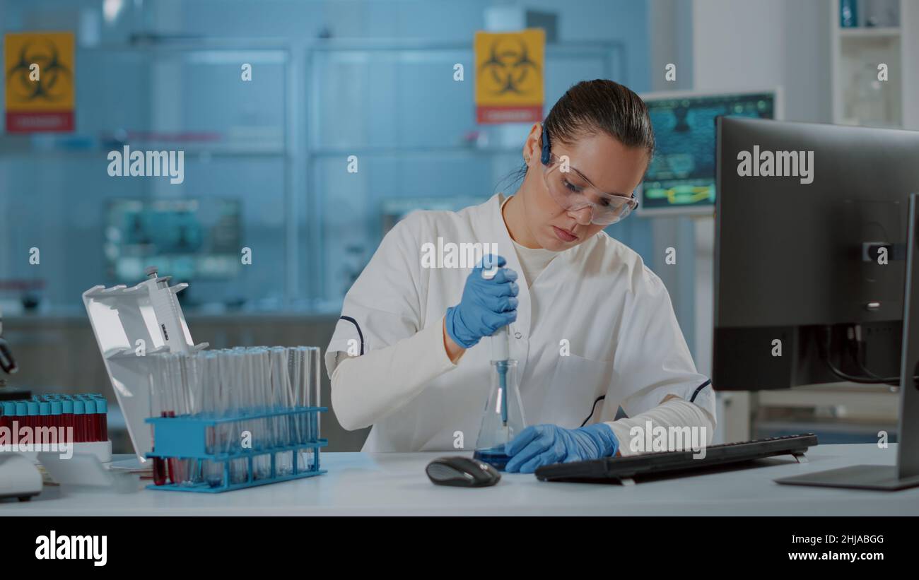 Scientist working with micro pipette for liquid in beaker and test tube ...