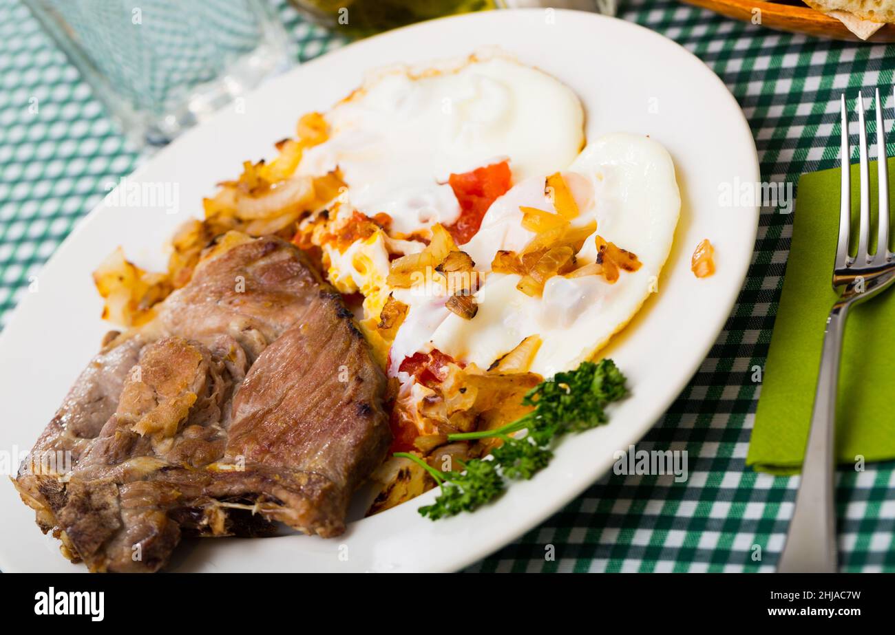 Tasty cooked fried pork with fried eggs at plate Stock Photo - Alamy
