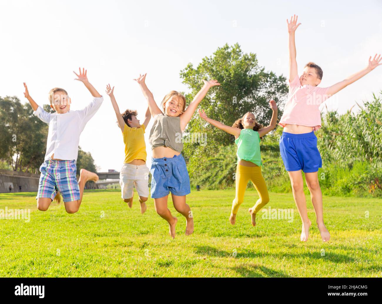 Children jumping and raising hands up Stock Photo - Alamy