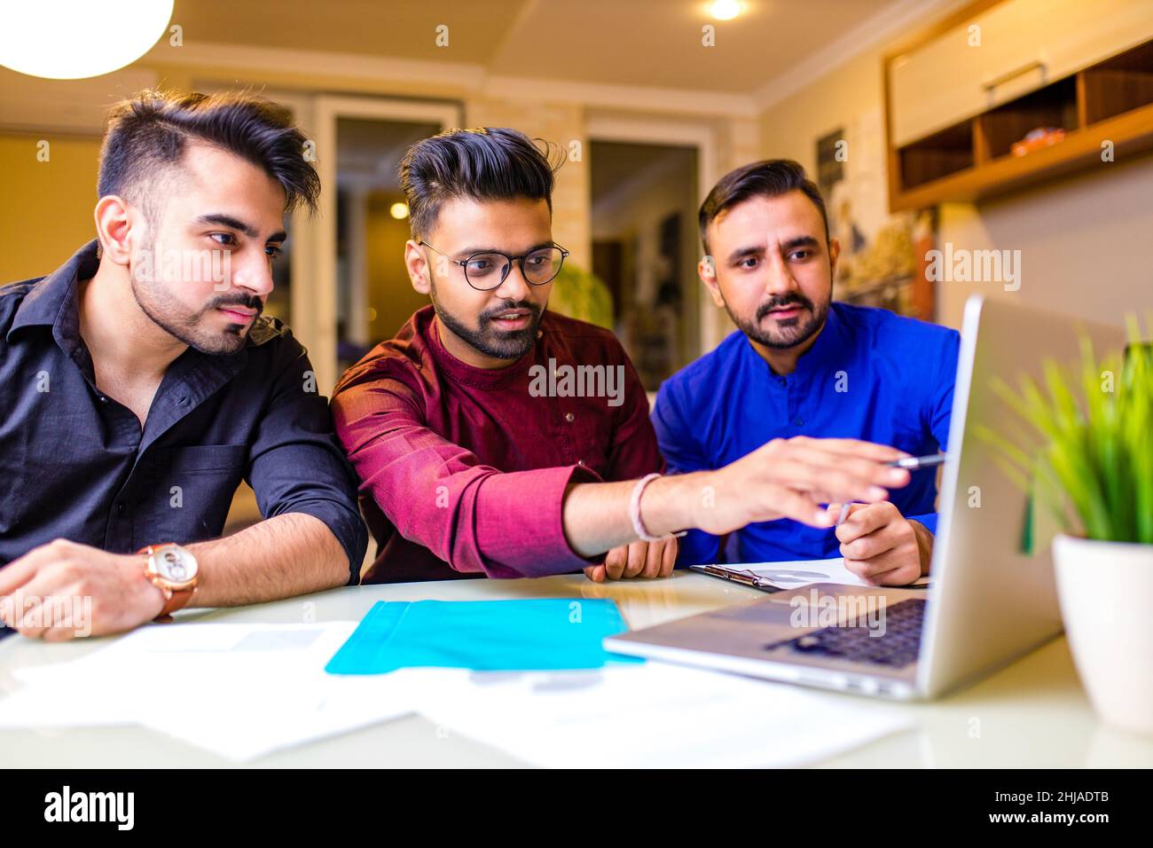 group of three indian students looking at laptop indoors Stock Photo ...