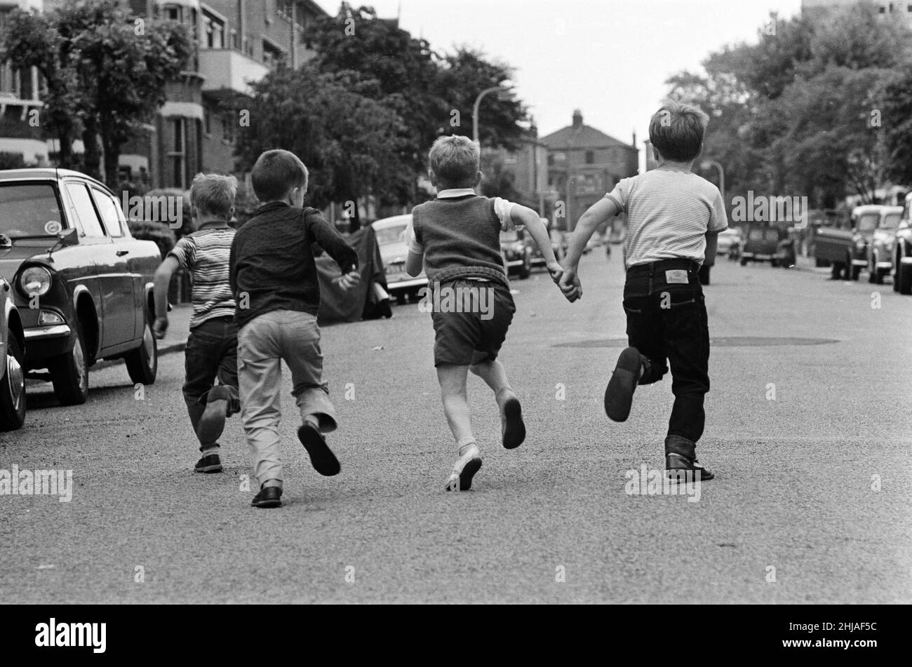 Children playing in the streets, running down the road. June 1964 Stock ...