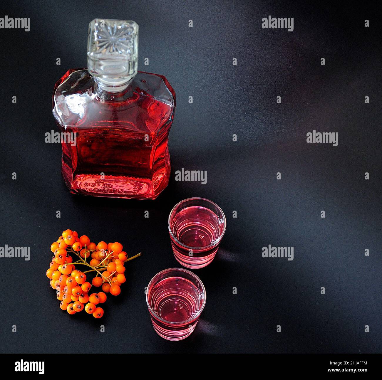 Homemade rowanberry liqueur, a bottle, two glasses with an alcoholic ...