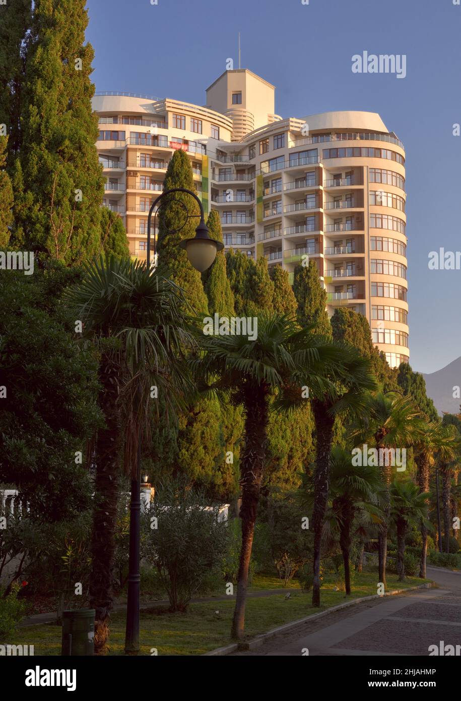 A tall building of modern architecture with a spire, balconies behind ...