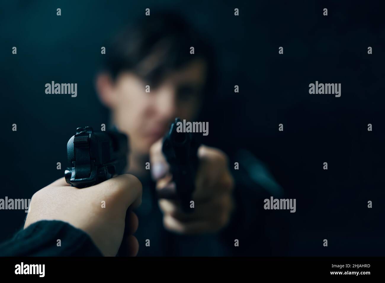 Close-up of man's hand with gun pointed at criminal with revolver Stock ...