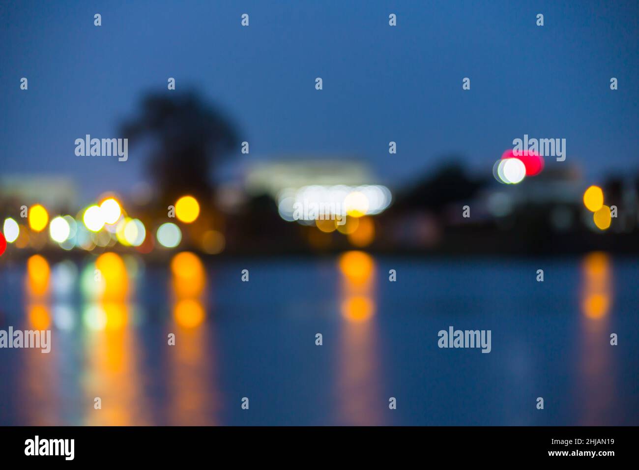Beautiful blurred city lights with bokeh effect reflected on water ...