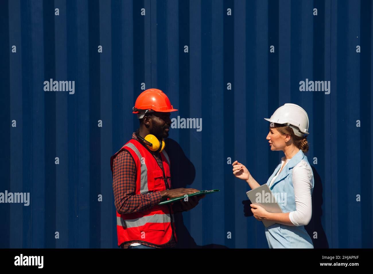Businesswoman and engineer talking and checking loading Containers box ...
