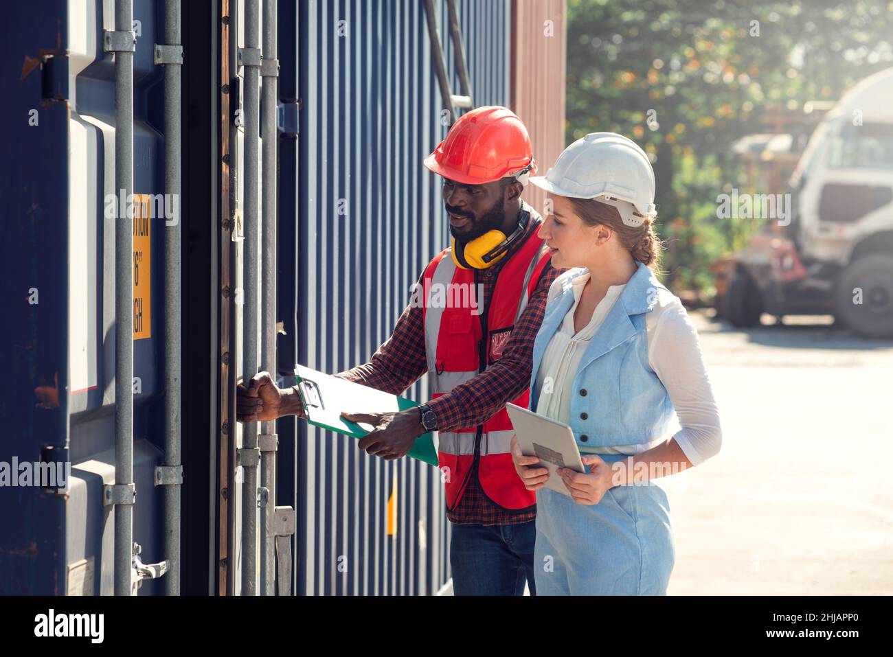 Businesswoman and engineer talking and checking loading Containers box ...