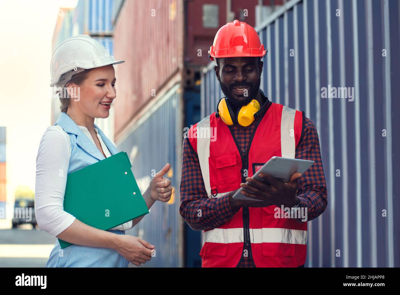 Businesswoman and engineer talking and checking loading Containers box ...