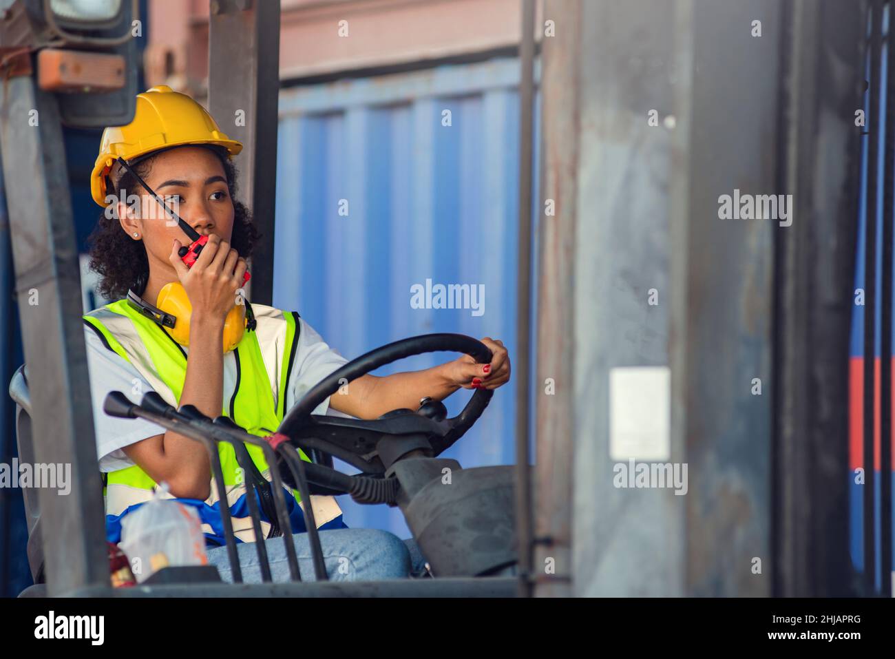 Female foreman use radio communication to communicate while driving ...