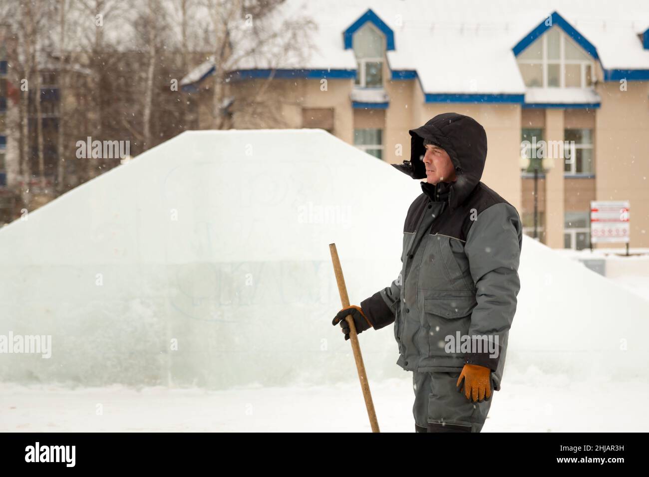 Construction worker clearing snow from the ice town Stock Photo - Alamy