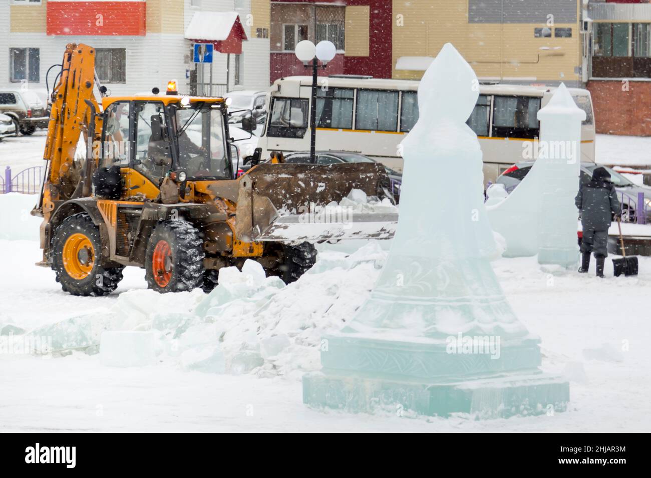 Construction worker clearing snow from the ice town Stock Photo - Alamy