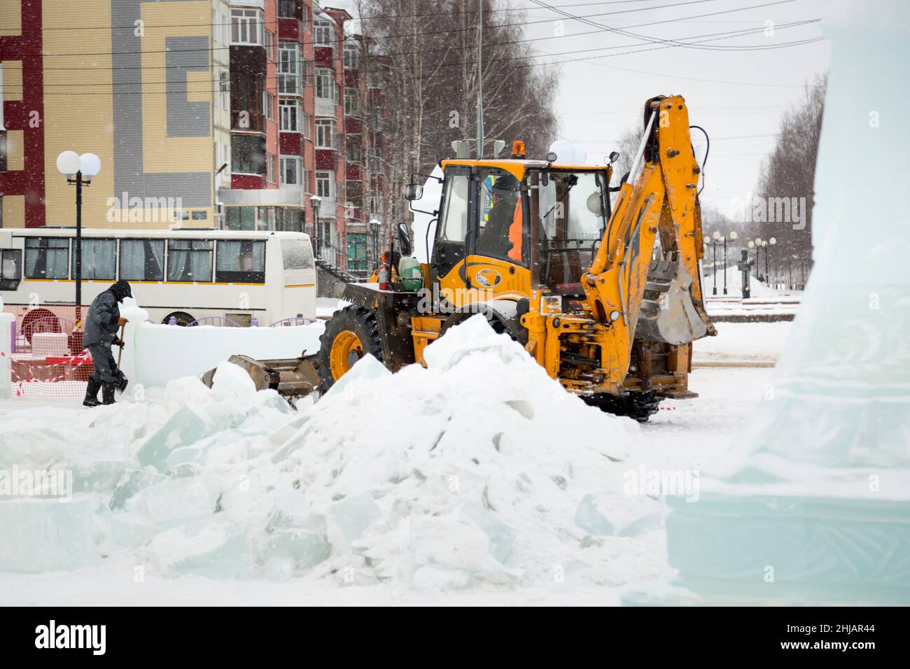 Construction worker clearing snow from the ice town Stock Photo - Alamy