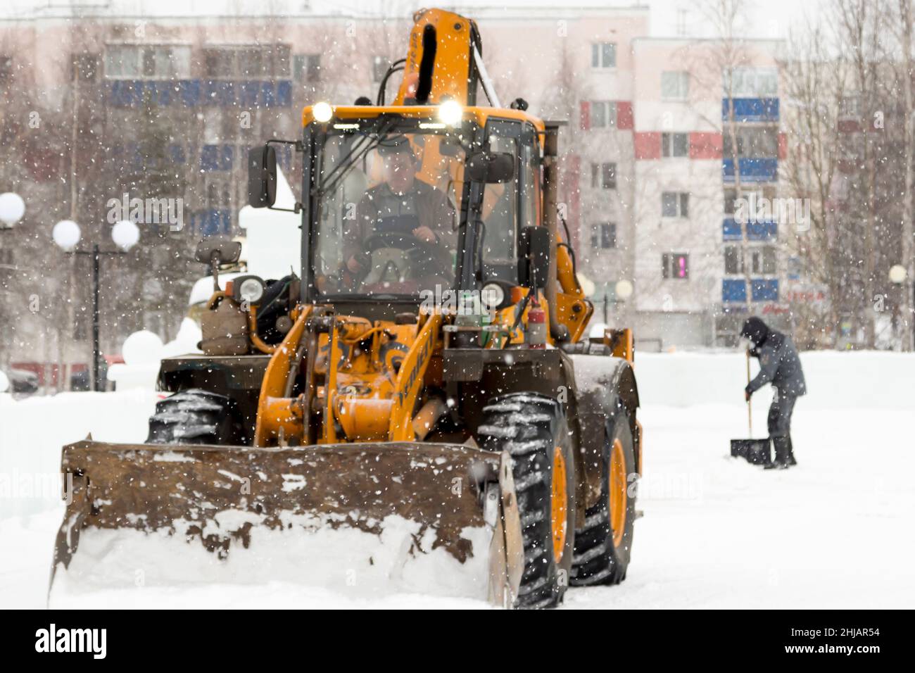 Construction worker clearing snow from the ice town Stock Photo - Alamy