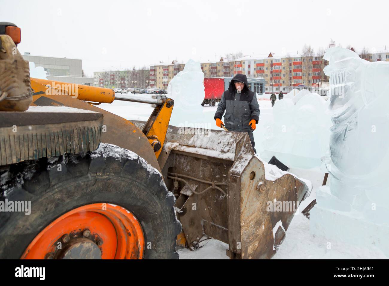 Construction worker clearing snow from the ice town Stock Photo - Alamy
