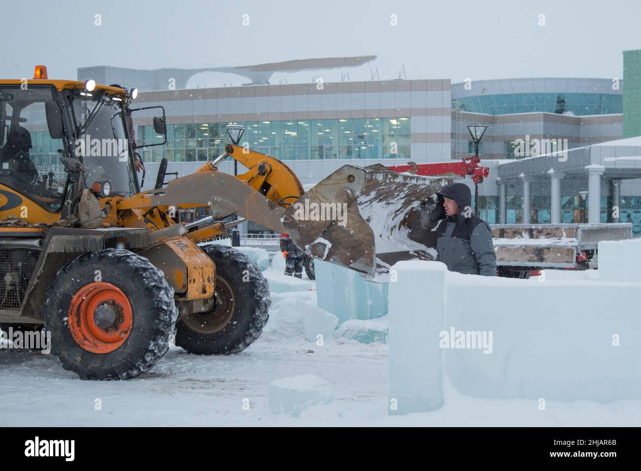 Construction worker clearing snow from the ice town Stock Photo - Alamy