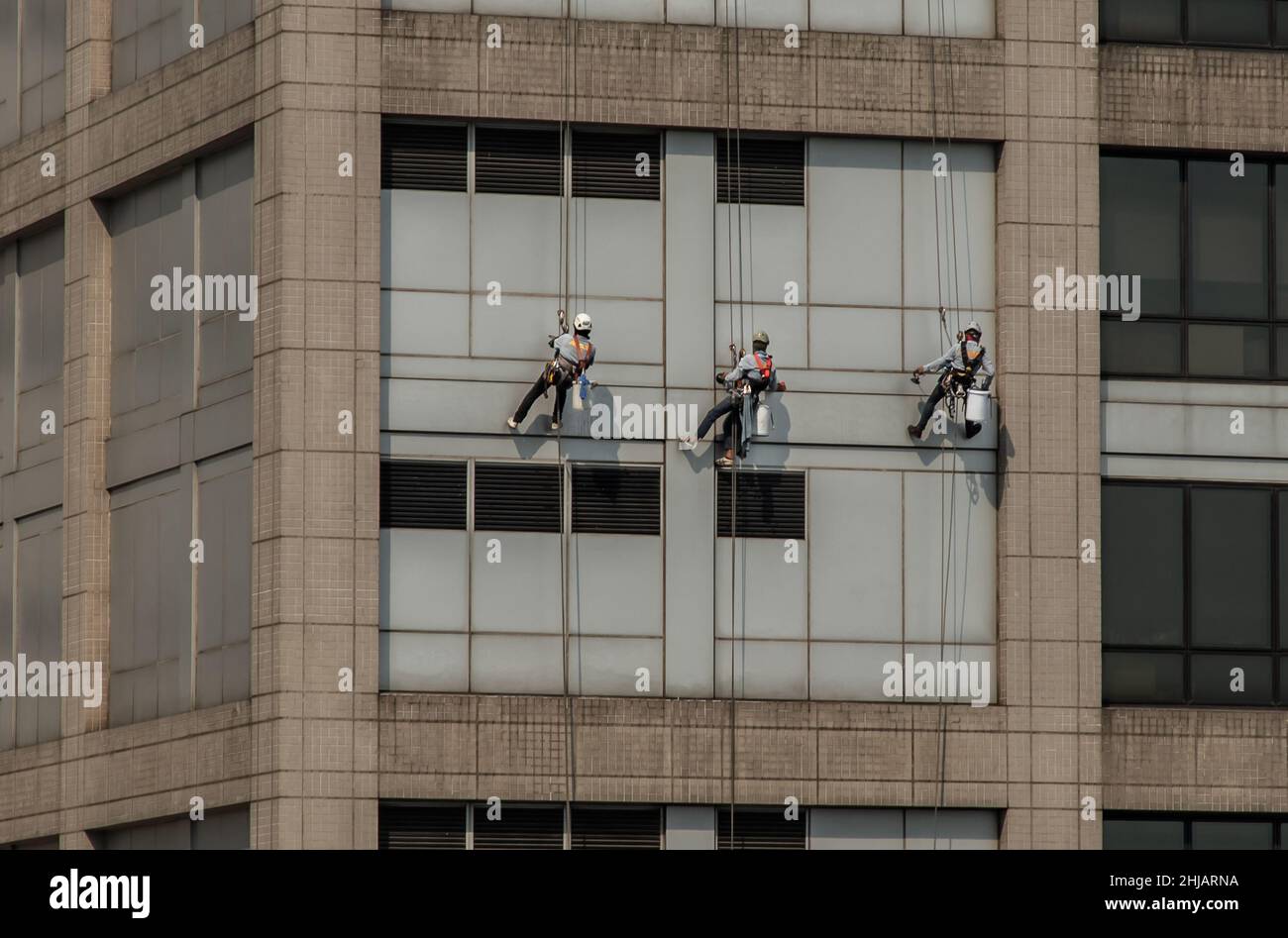 Group of workers cleaning windows service on high rise office building ...