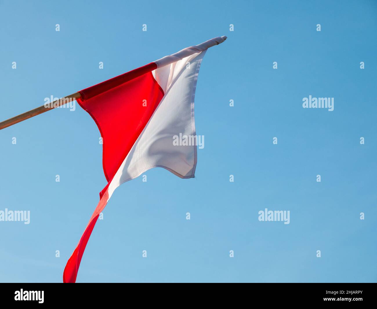 Polish red white flag on blue sky background Stock Photo - Alamy