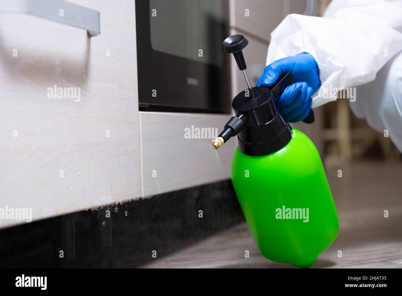 Spray gun with pesticides close-up. An exterminator in work clothes ...