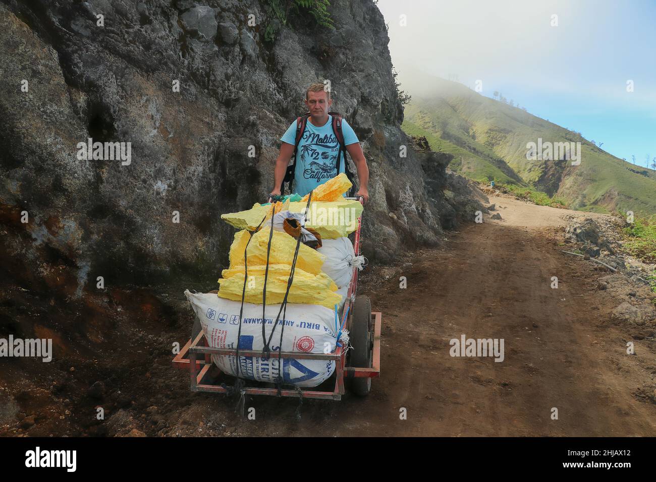 Man with a cart on the top of active Kawah Ijen volcano with a load of ...