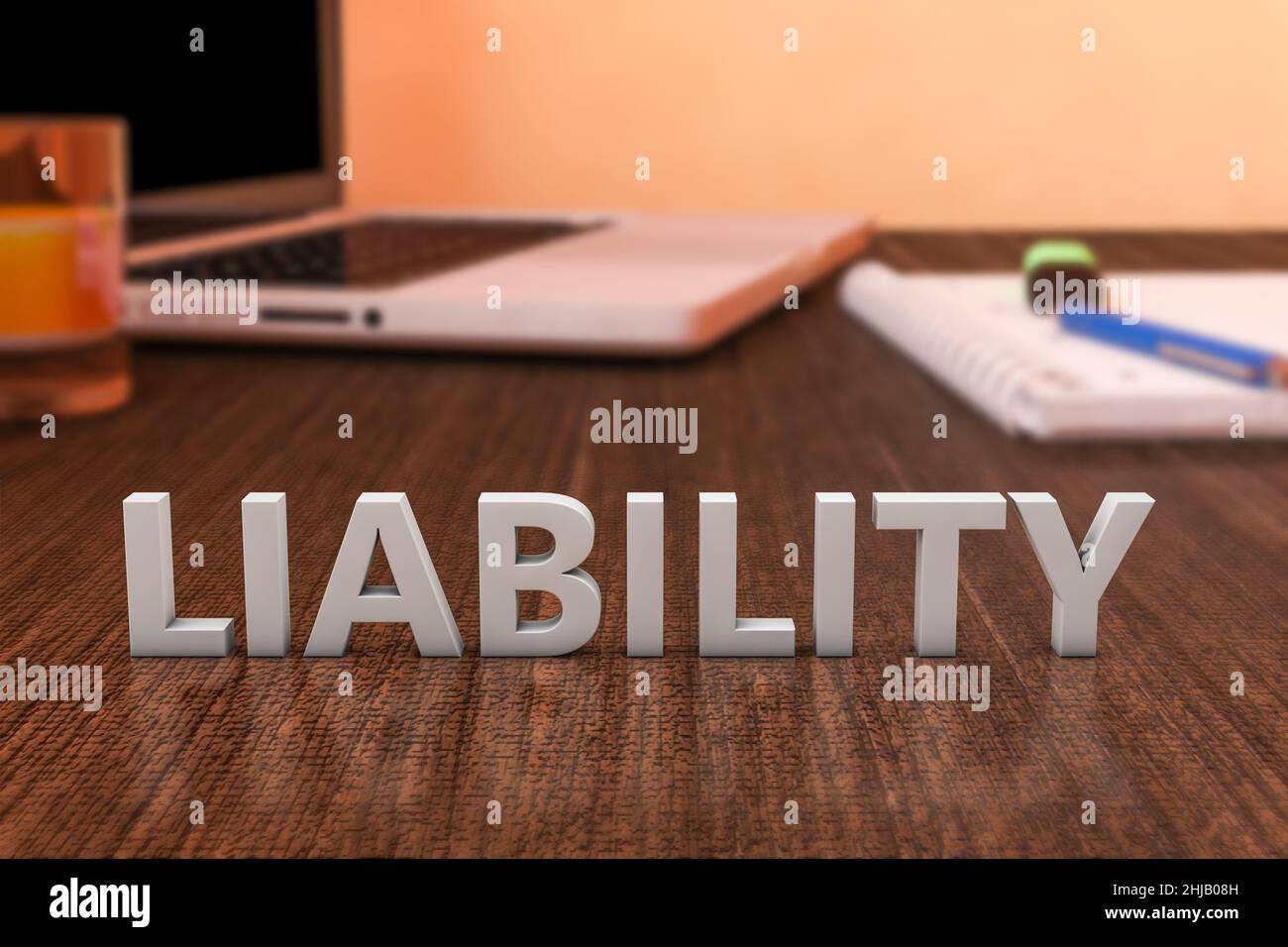 Liability - letters on wooden desk with laptop computer and a notebook ...