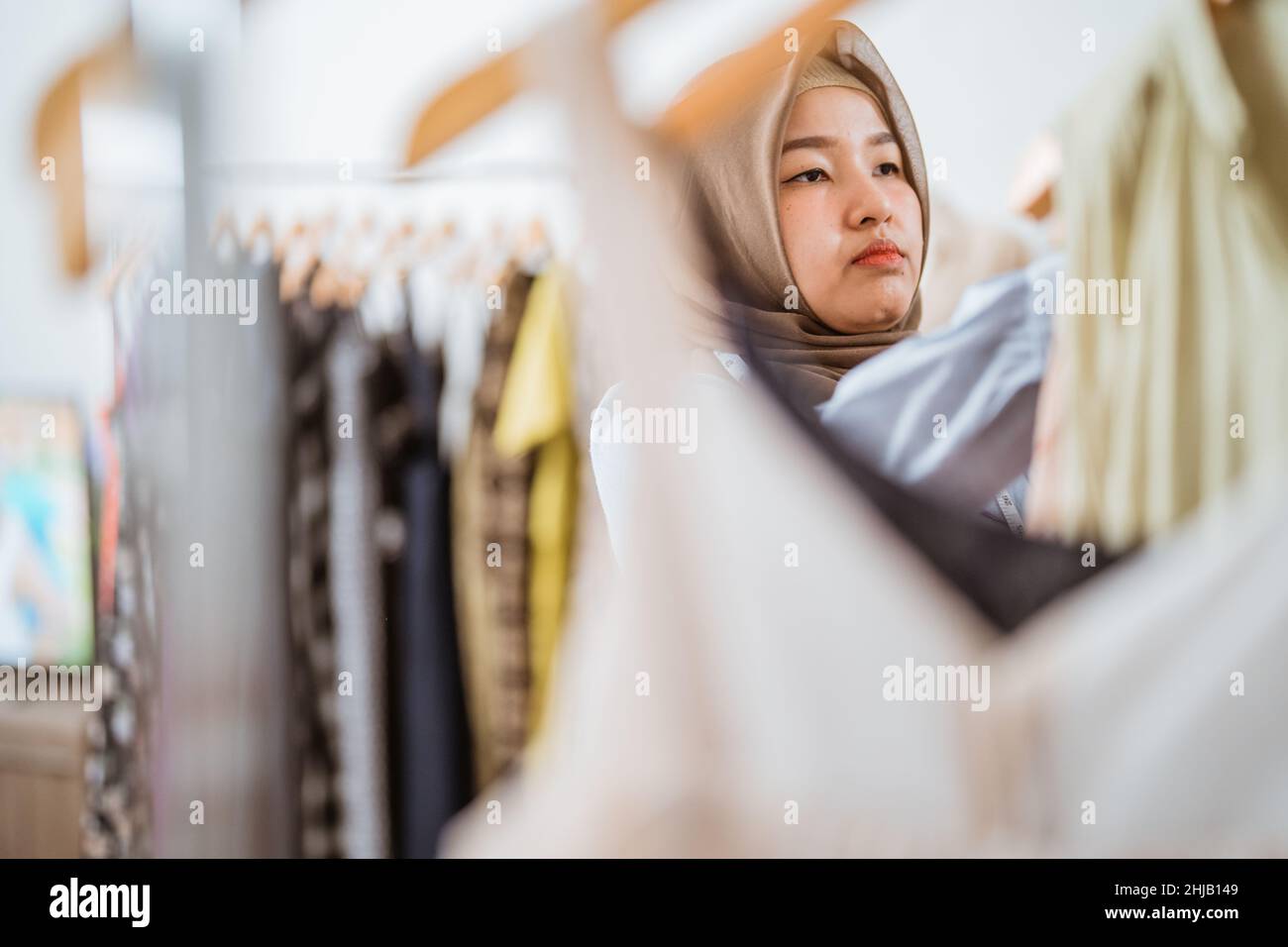 hand gesture taking clothes hanger at fashion store Stock Photo - Alamy