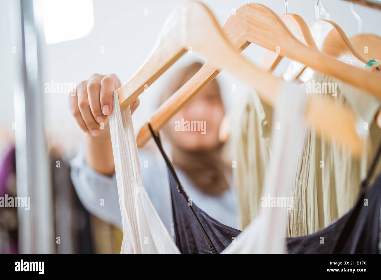 hand gesture taking clothes hanger at fashion store Stock Photo - Alamy